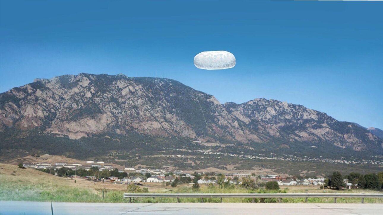 Um objeto em forma de batata sobre uma montanha e orbes que se ...